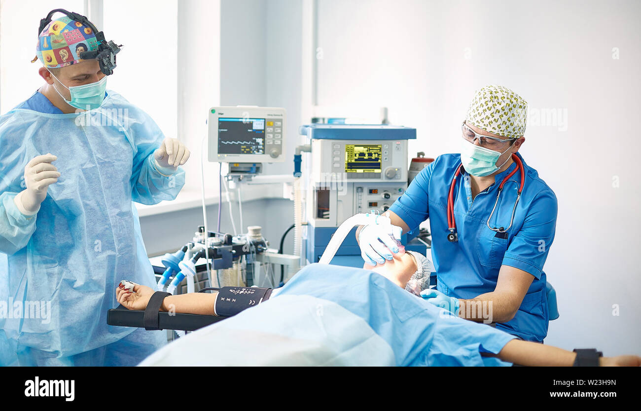 Several doctors surrounding patient on operation table during their ...