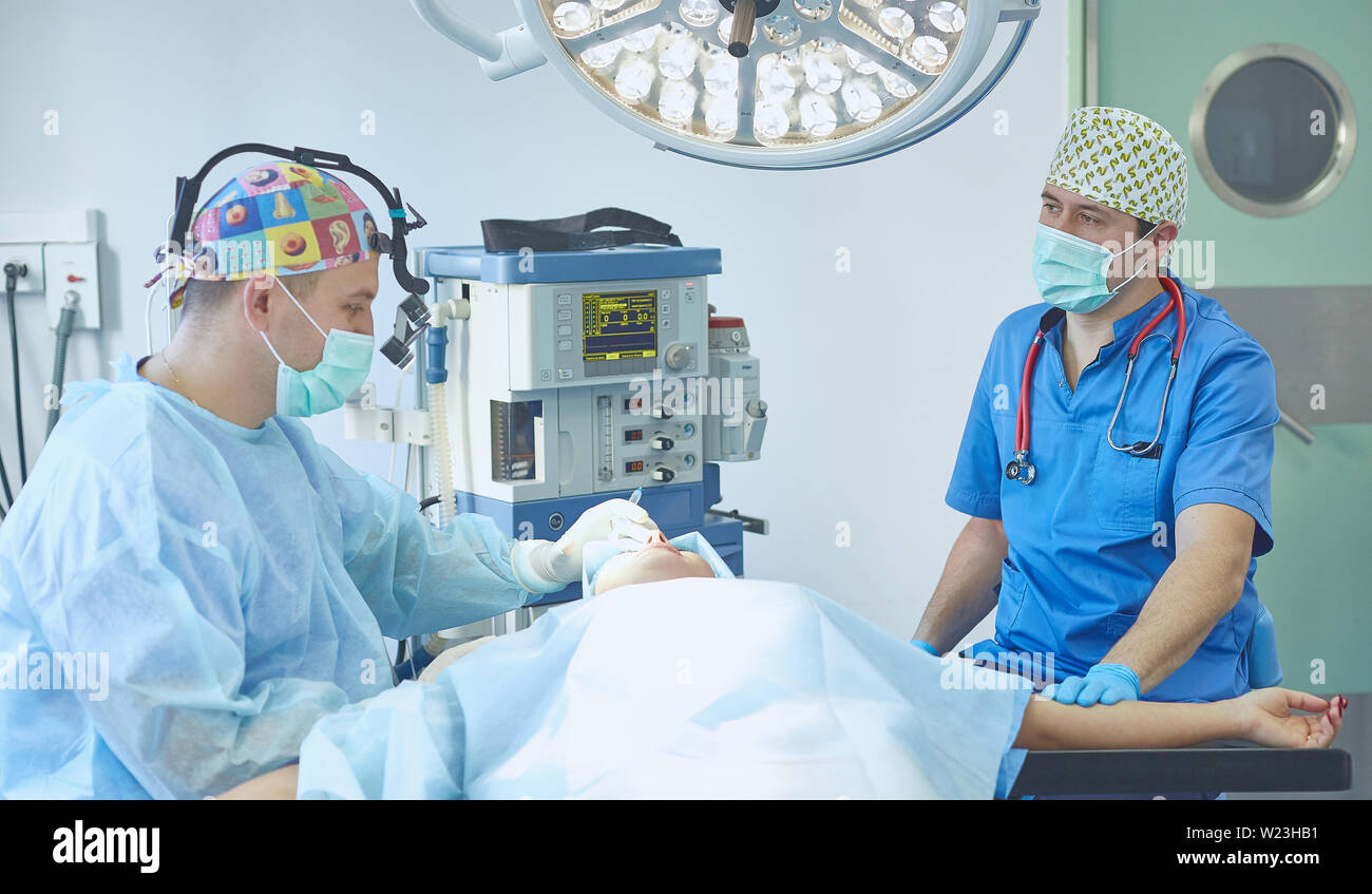 Several doctors surrounding patient on operation table during their ...