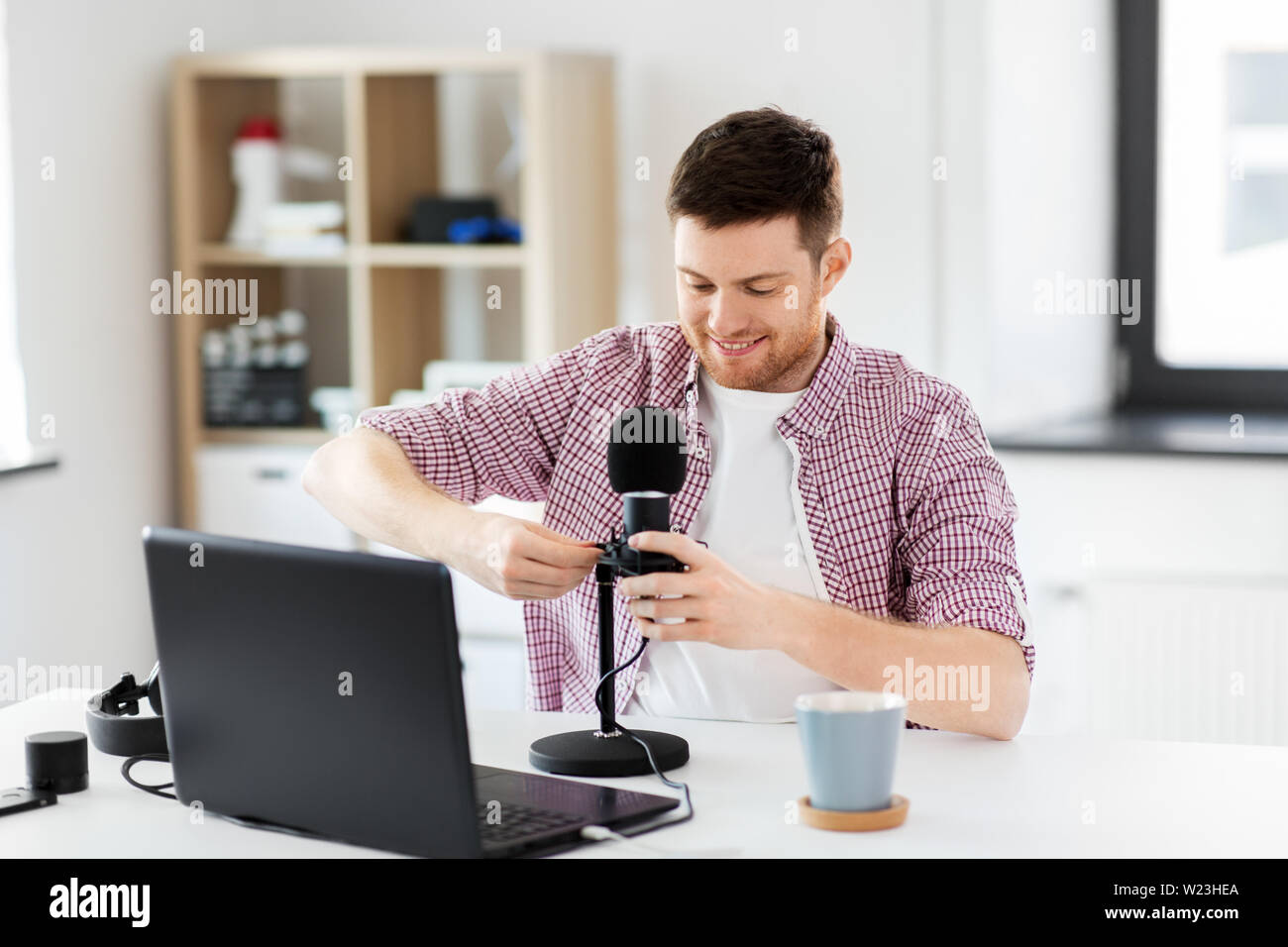 male audio blogger connecting cable to microphone Stock Photo - Alamy