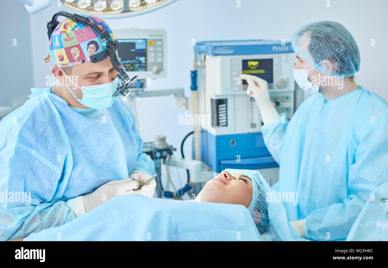 Several doctors surrounding patient on operation table during their ...
