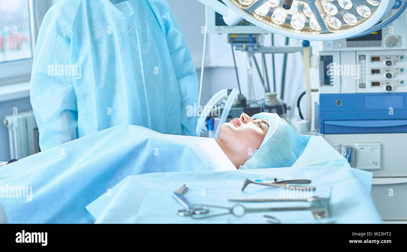 Several doctors surrounding patient on operation table during their ...