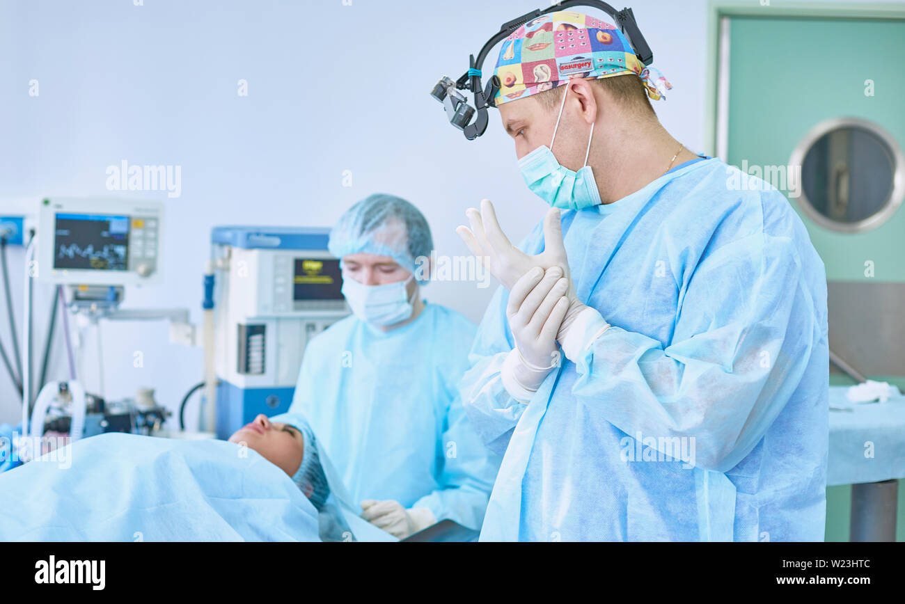Several doctors surrounding patient on operation table during their ...