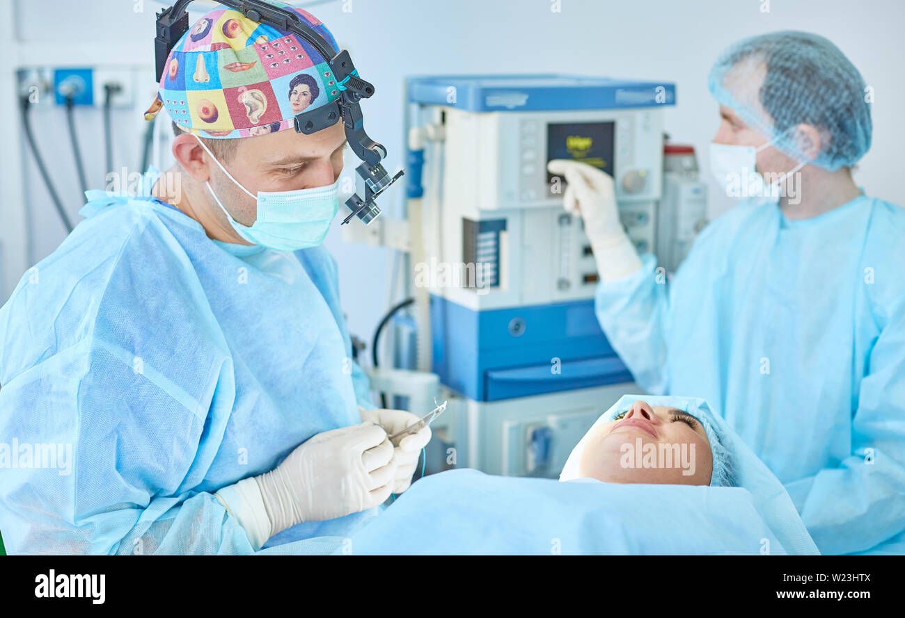 Several doctors surrounding patient on operation table during their ...