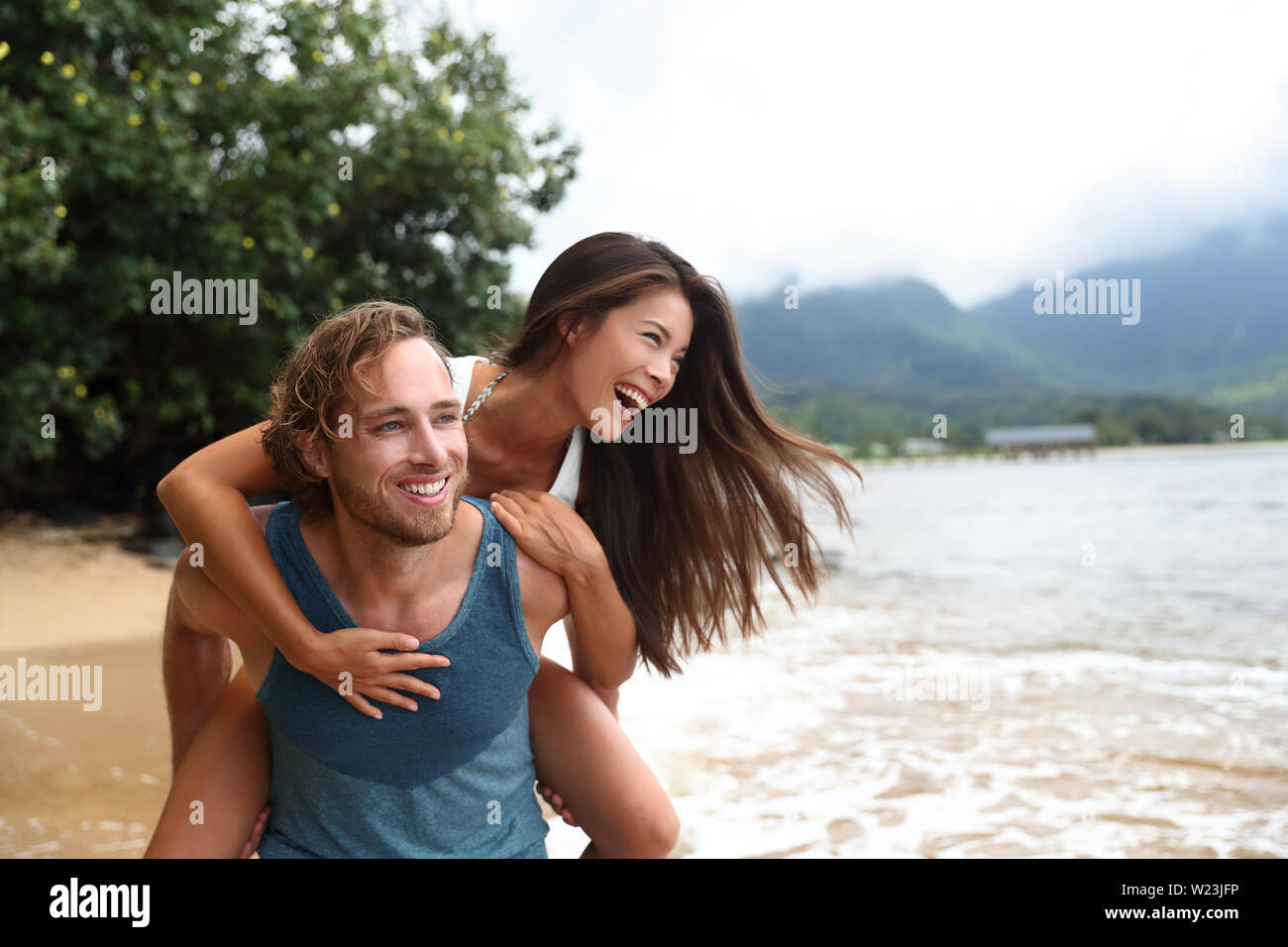 Couple laughing piggyback piggy back beach hi-res stock photography and ...