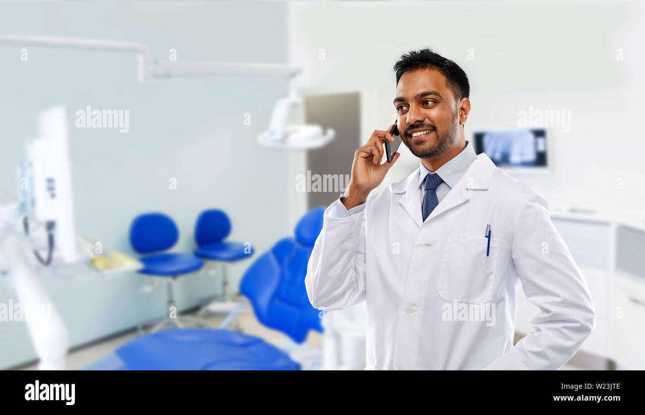 dentist calling on smartphone at dental clinic Stock Photo - Alamy