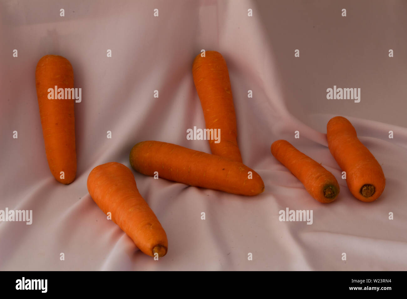 Group of beautiful carrots on a white fabric background Stock Photo - Alamy