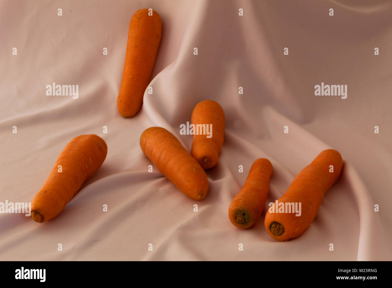 Group of beautiful carrots on a white fabric background Stock Photo - Alamy