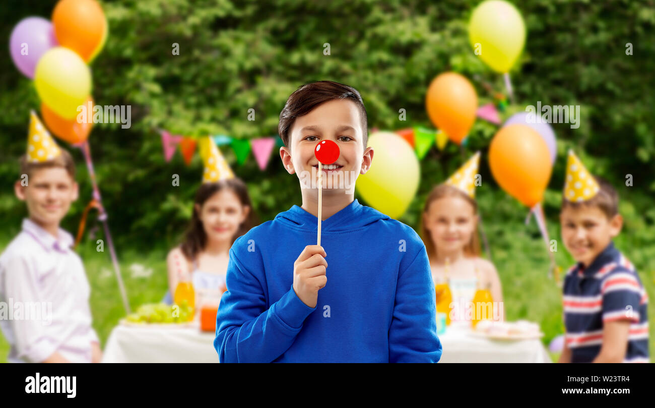 happy boy with red clown nose at birthday party Stock Photo - Alamy
