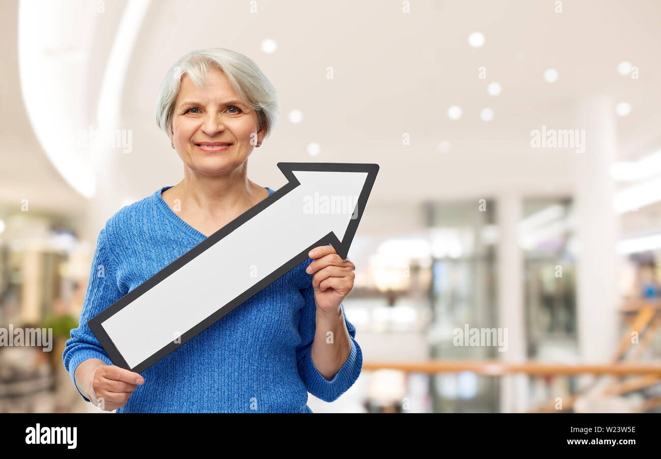 smiling senior woman with big rightwards arrow Stock Photo - Alamy