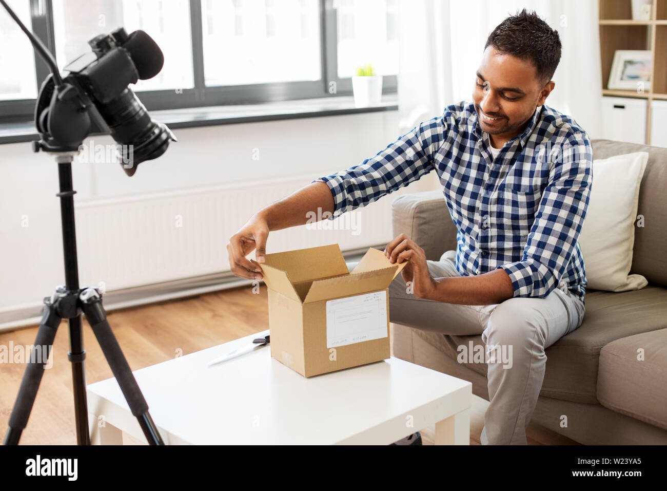 male video blogger opening parcel box at home Stock Photo - Alamy