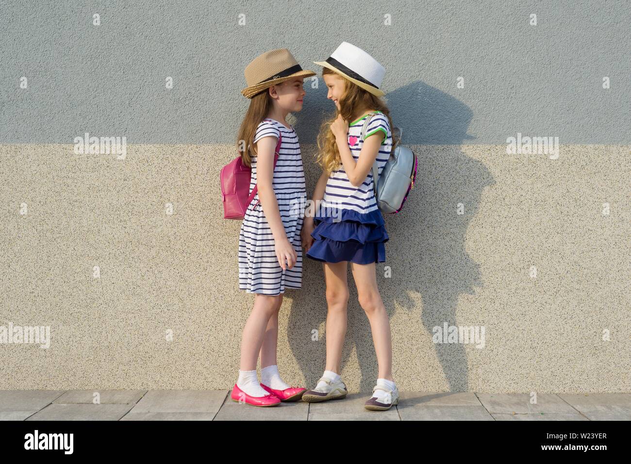 Outdoor summer portrait of two happy girl friends 7,8 years in profile ...