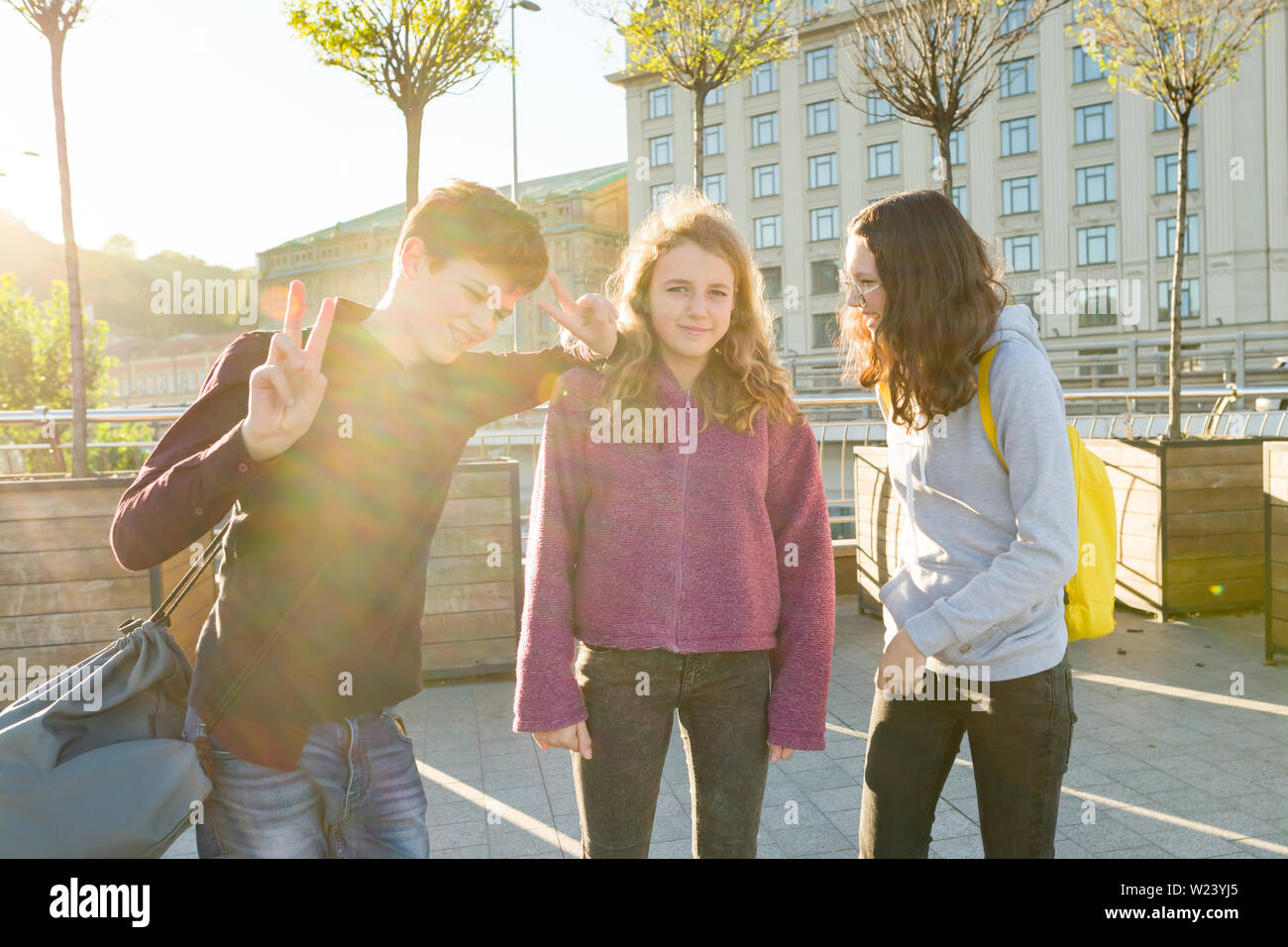 Friends teenagers students with school backpacks, having fun on the way ...