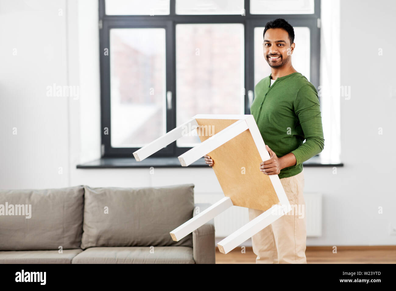 happy indian man holding coffee table at home Stock Photo - Alamy