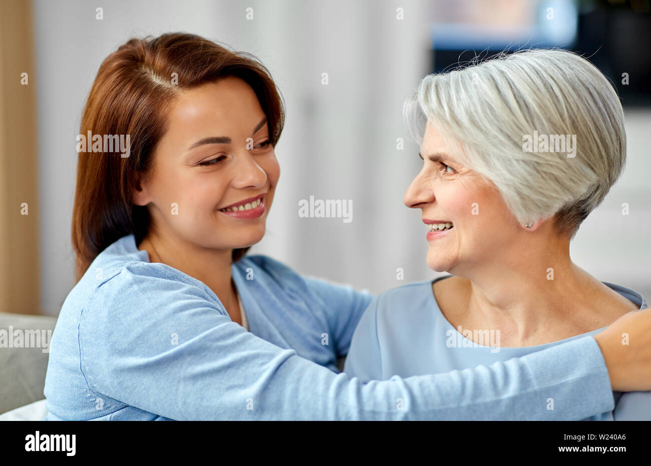 senior mother with adult daughter hugging at home Stock Photo - Alamy