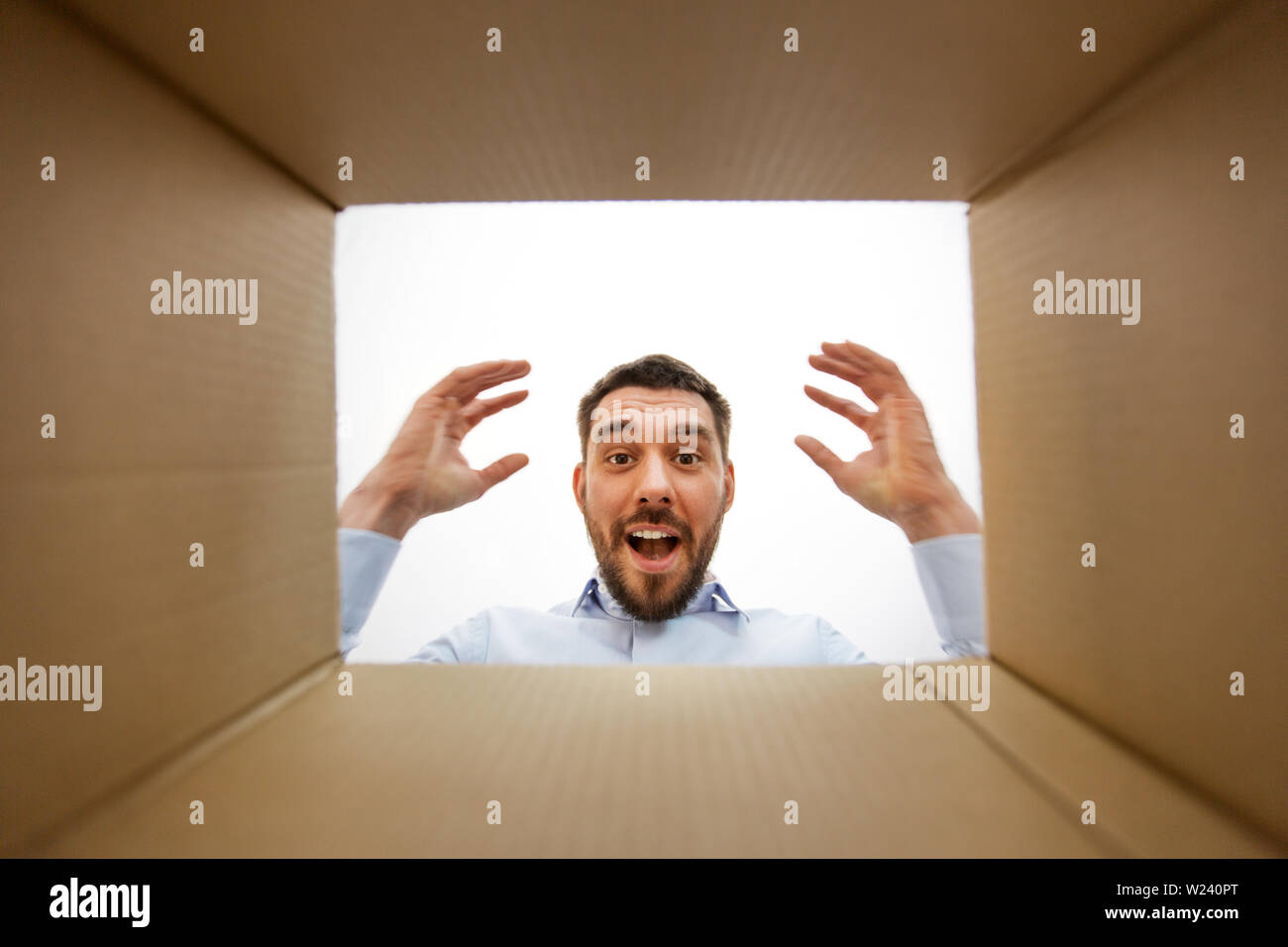 happy suprised man looking into open parcel box Stock Photo - Alamy