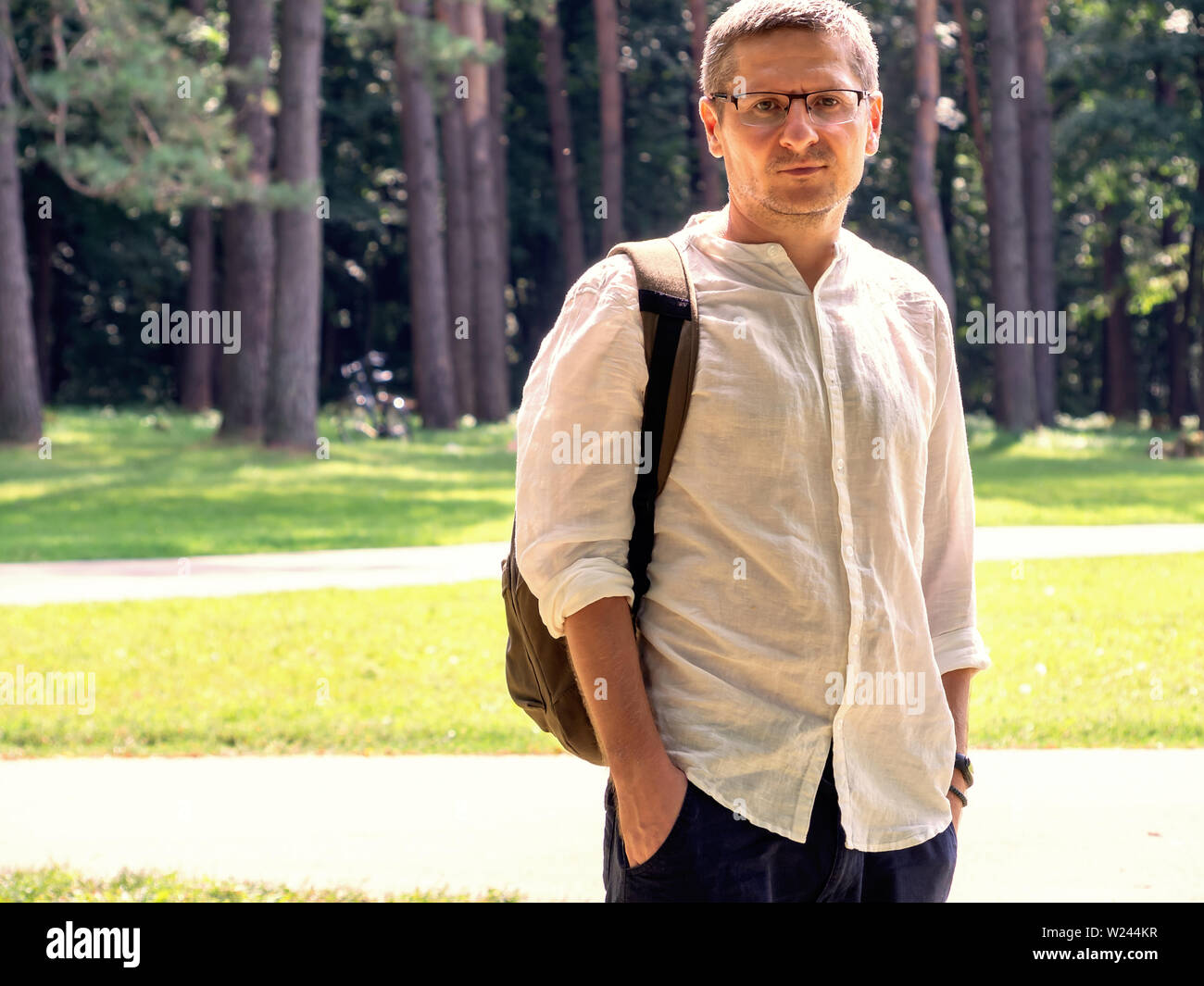 Sad caucasian 40 years man in the glasses, white shirt, outdor portrait ...