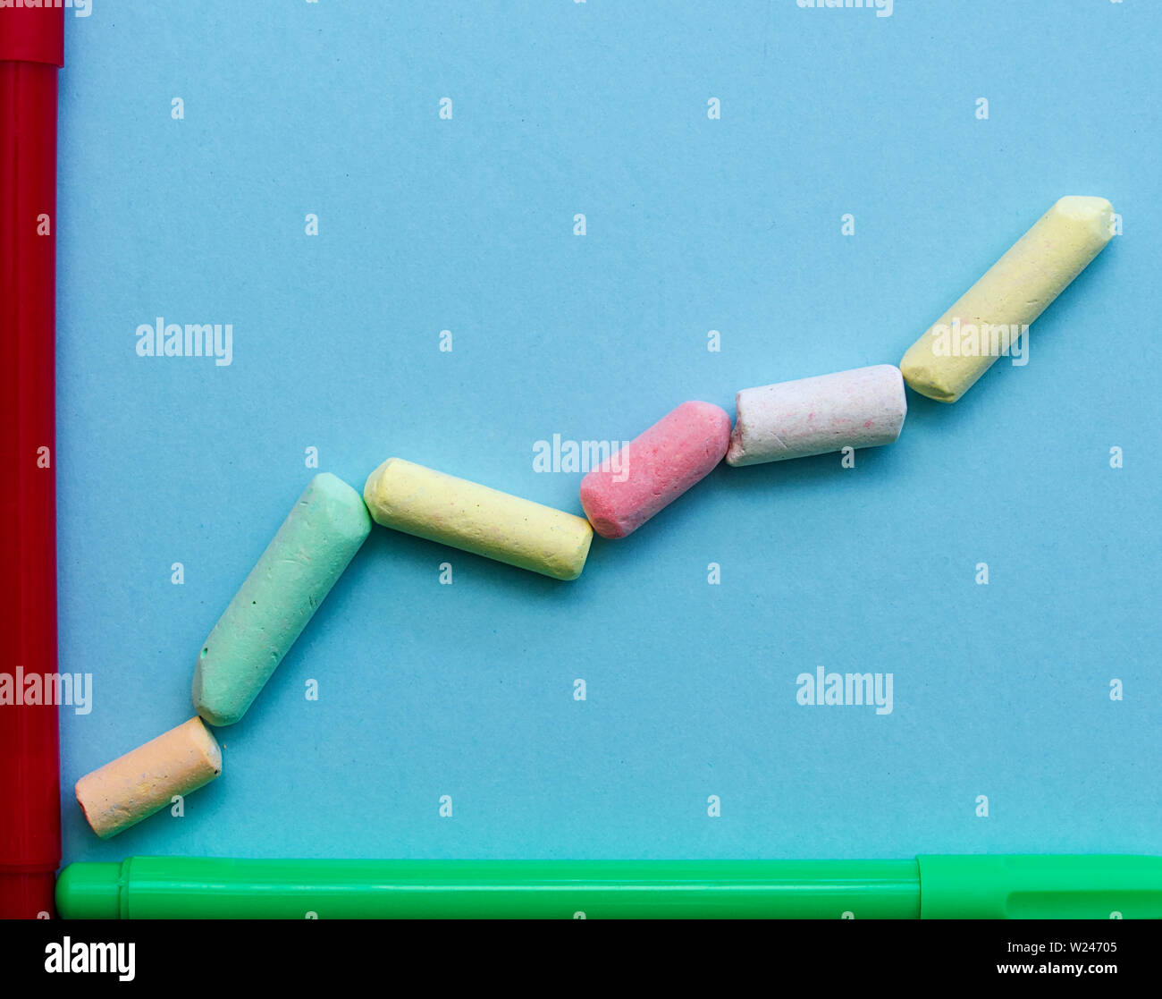 Uptrend line graph made with colorful Chalk pieces and markers on light ...