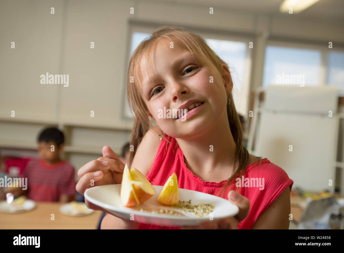 Elementary School Girl Having Healthy Snack In Classroom At School ...