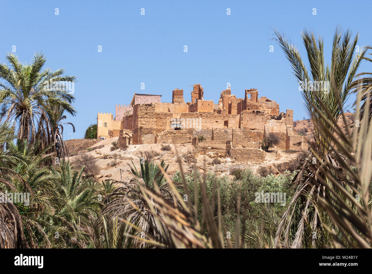 The Kasbah (Arabic, means fortress) of Tiout surrounded by palm trees ...