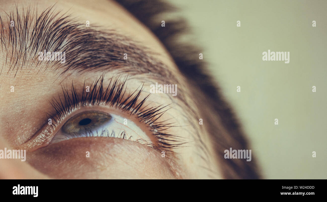 a man drips open human eye with bright red arteries drops to improve ...