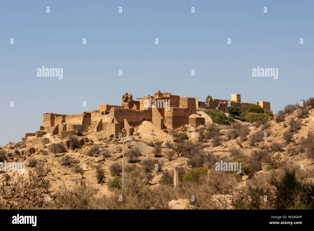 The Kasbah (Arabic, means fortress) of Tiout surrounded by palm trees ...
