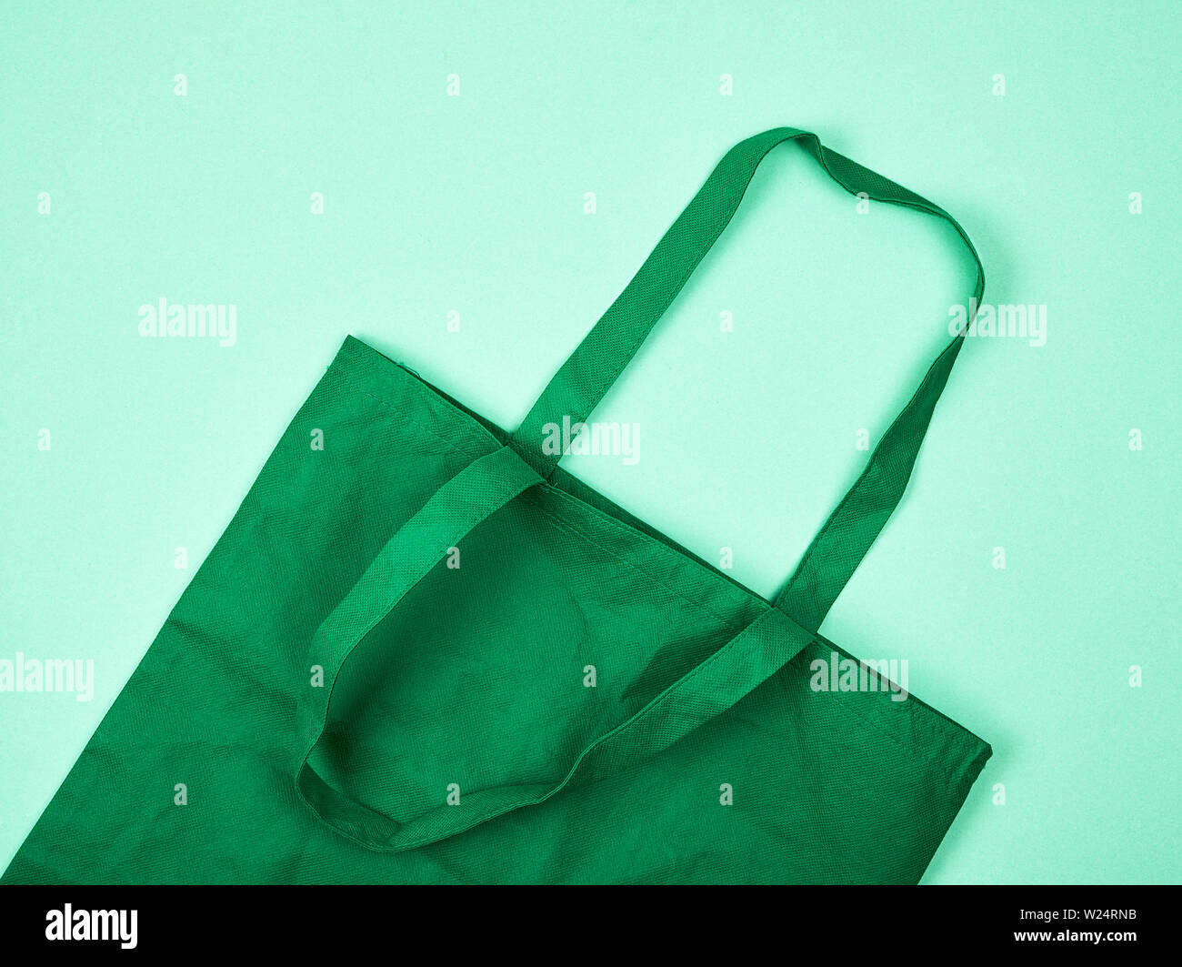 empty green ecological bag made of viscose with long handles, concept ...