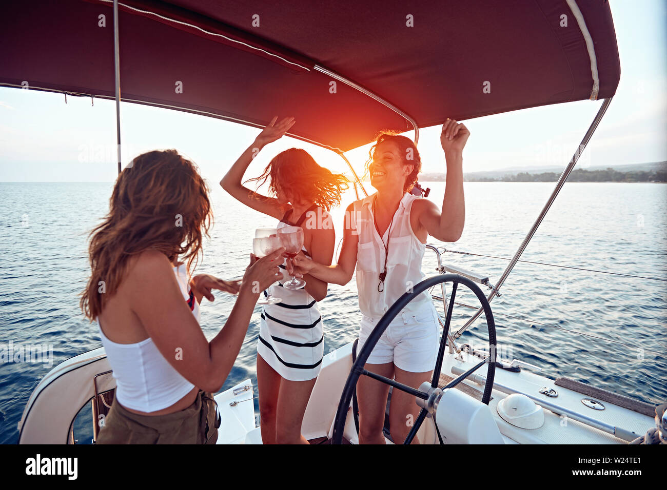 Young girls enjoy the vacation on a yacht. Party on a sailboat Stock ...
