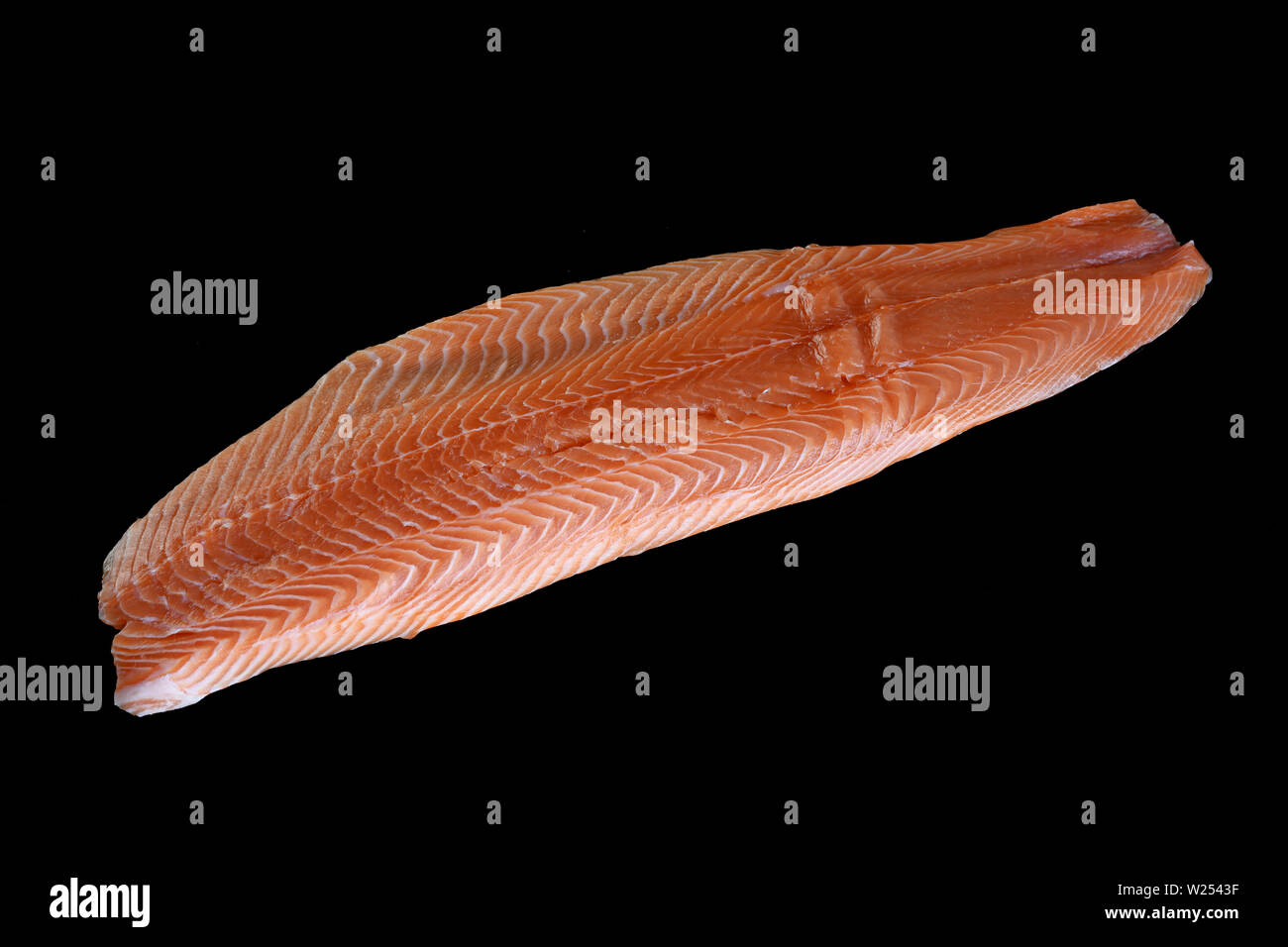A full side of a raw salmon fillet over black background Stock Photo ...