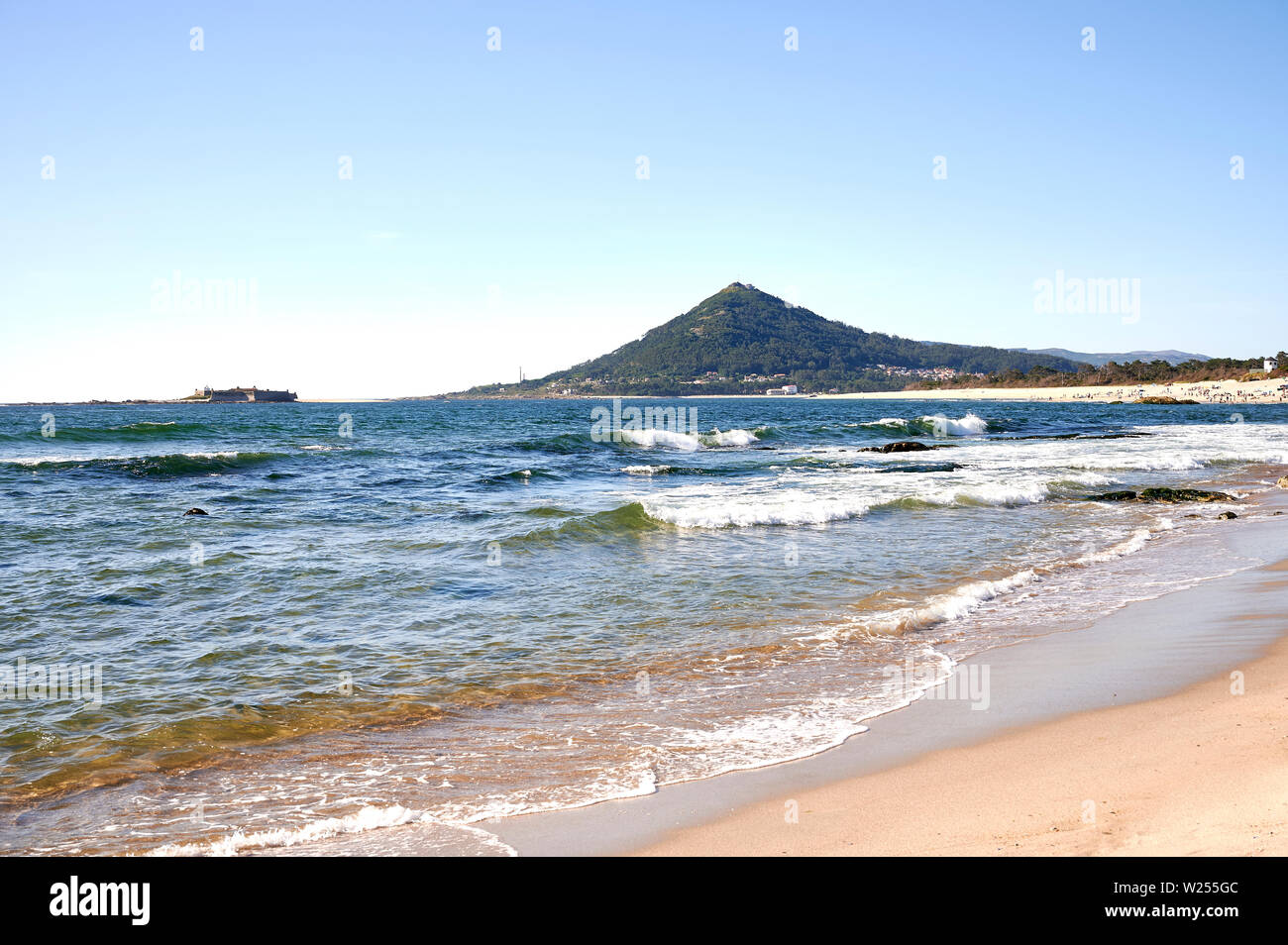 Moledo beach on a spring day, with waves on the sea and a mountain in ...