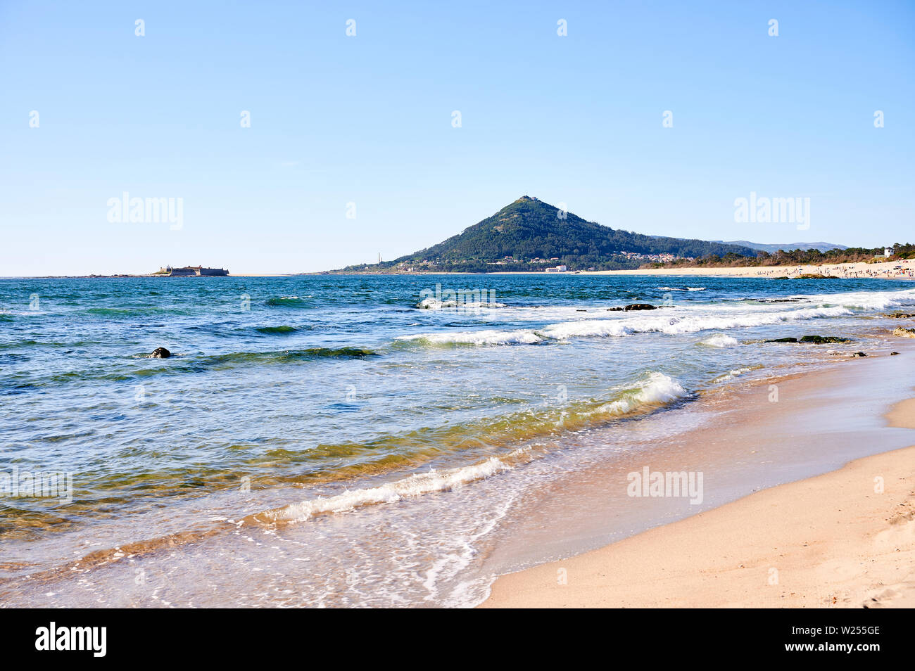 Moledo beach on a spring day, with waves on the sea and a mountain in ...