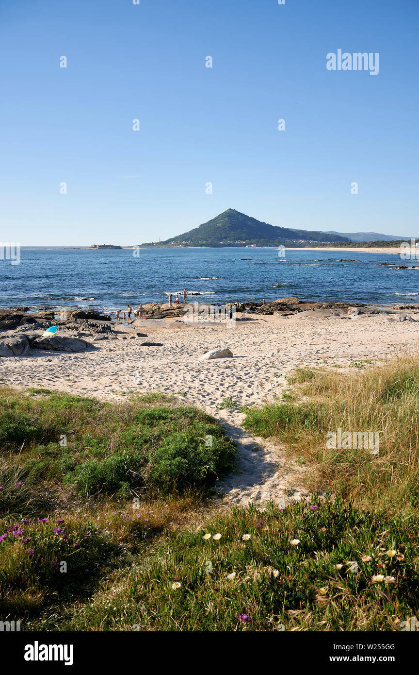Moledo beach on a spring day, with waves on the sea and a mountain in ...