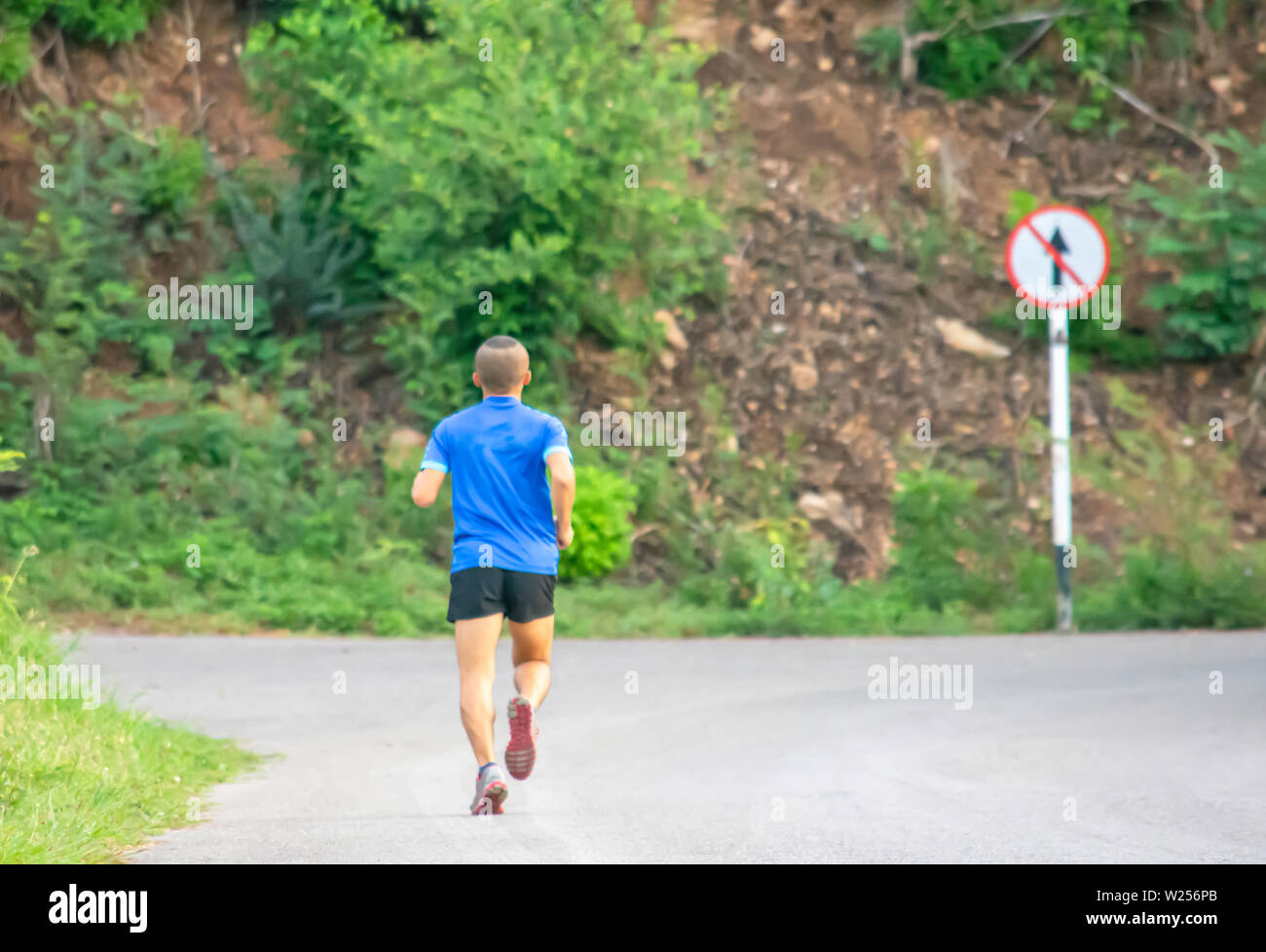 The men are running on the road Background trees and Traffic signs ...