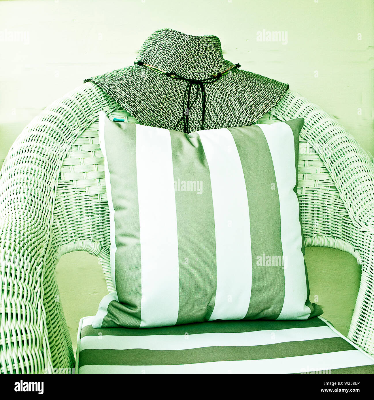Hat on back of wicker chair Stock Photo - Alamy