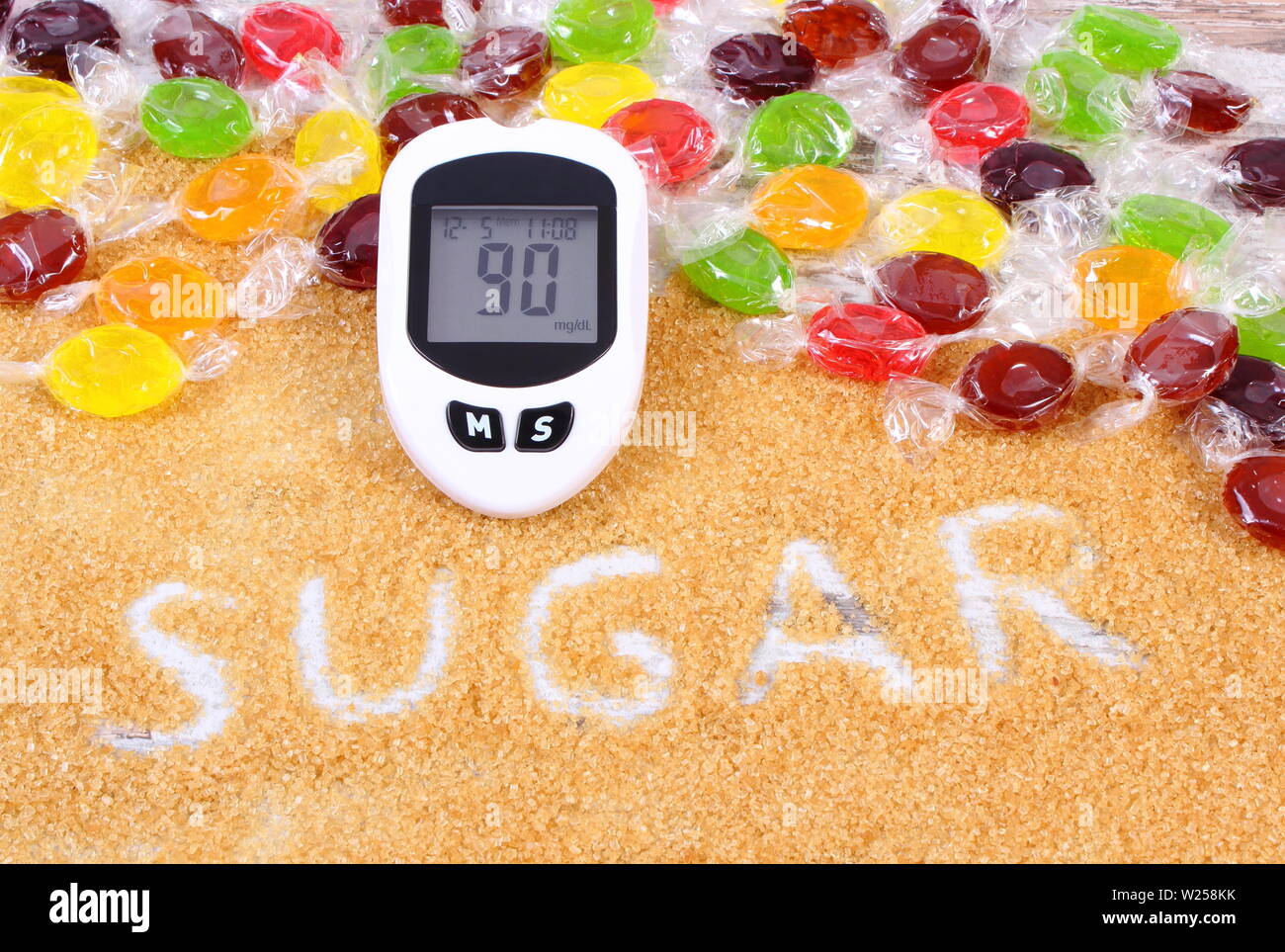 Glucometer for checking sugar level, colorful candies and natural brown ...