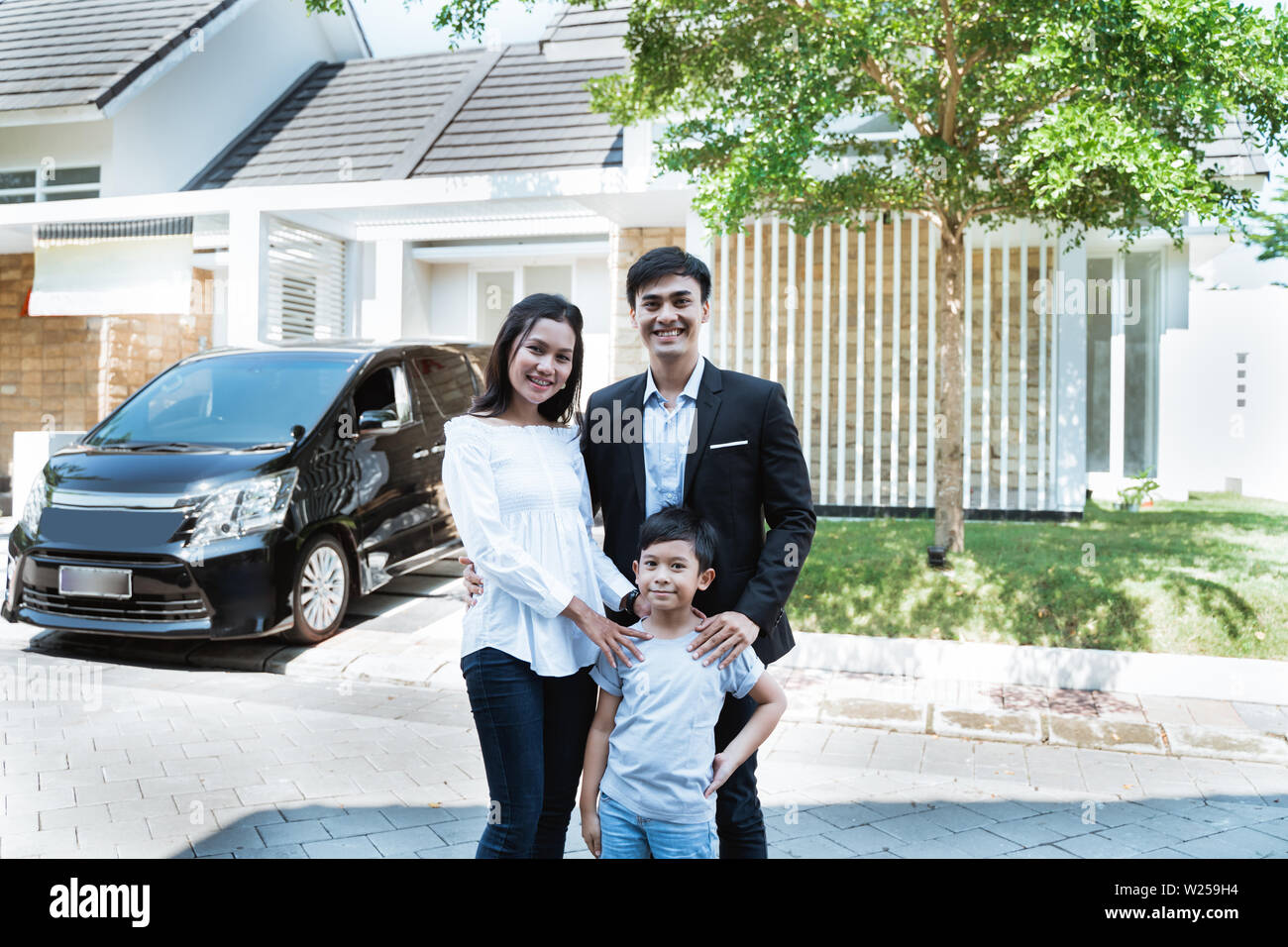 parent with kid in front of their car smiling to camera Stock Photo - Alamy