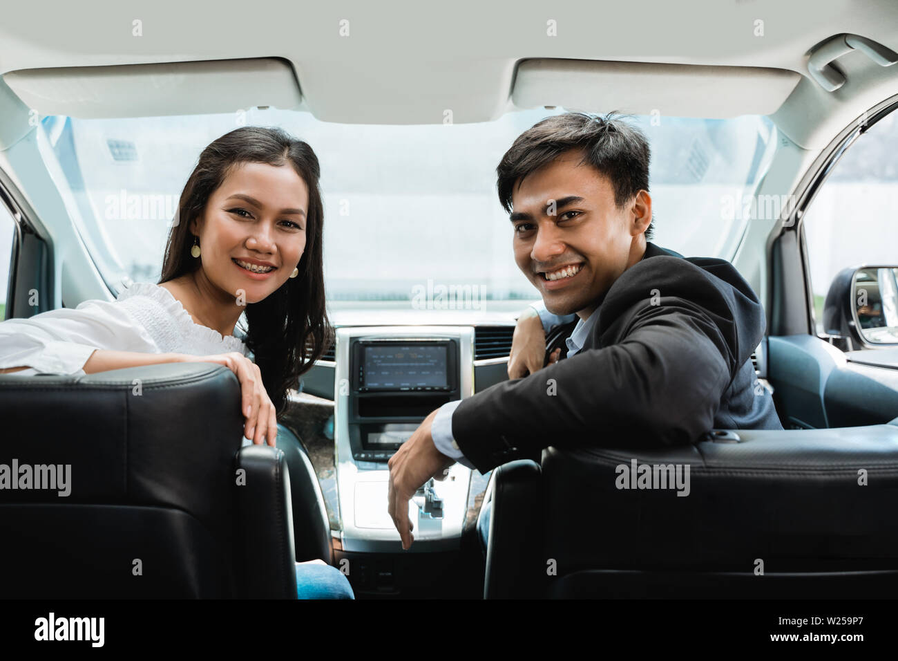 two asian people in suit driving a car looking back to camera Stock ...