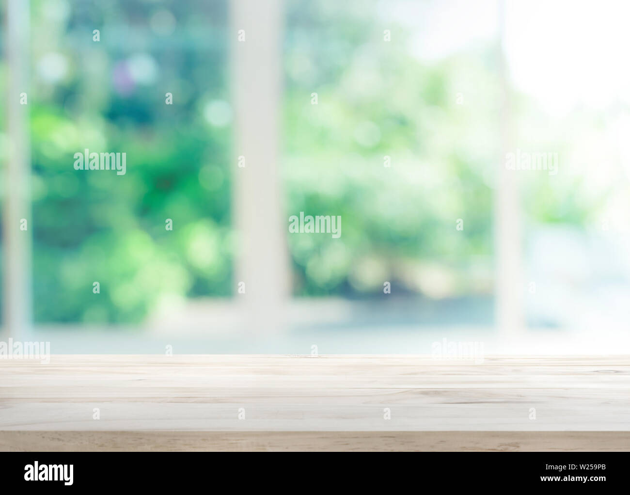 Wood table top on blur of window with garden flower background in ...