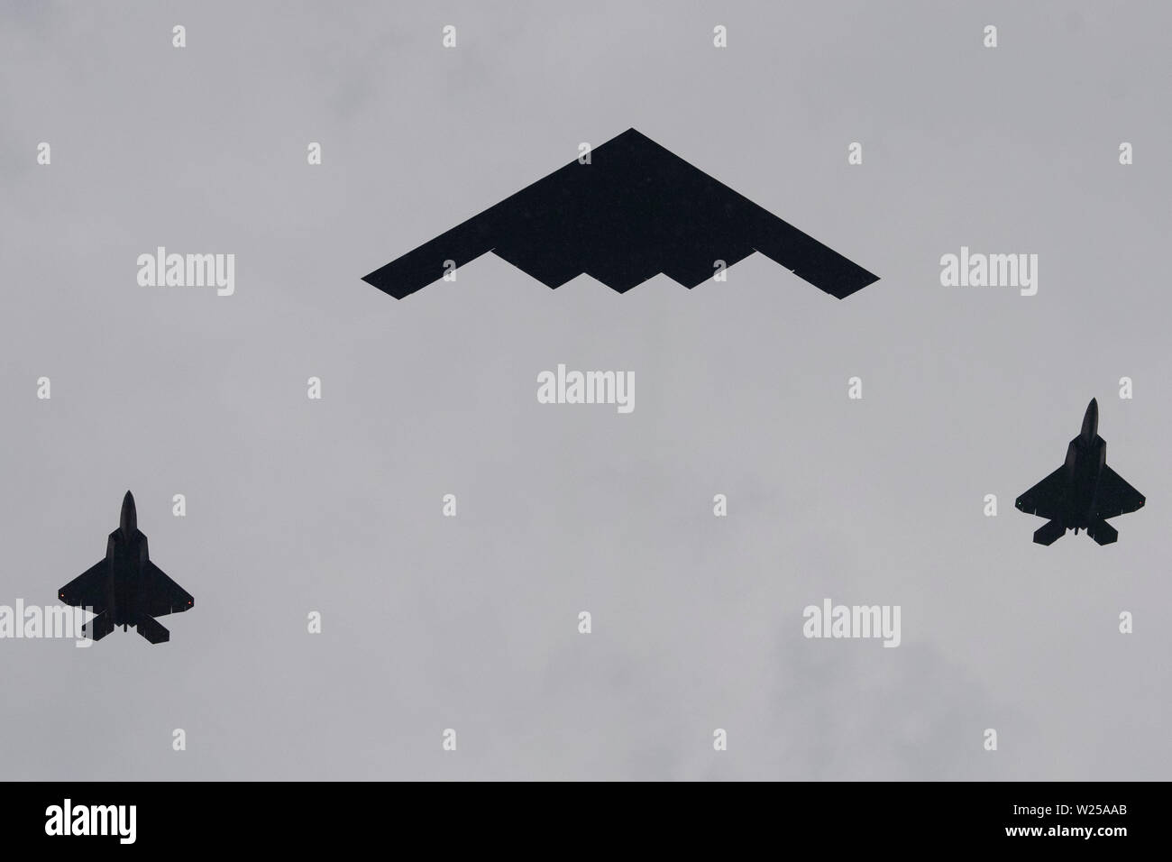 Air Force F-22s and a B-2 stealth bomber conduct a flyover during the ...