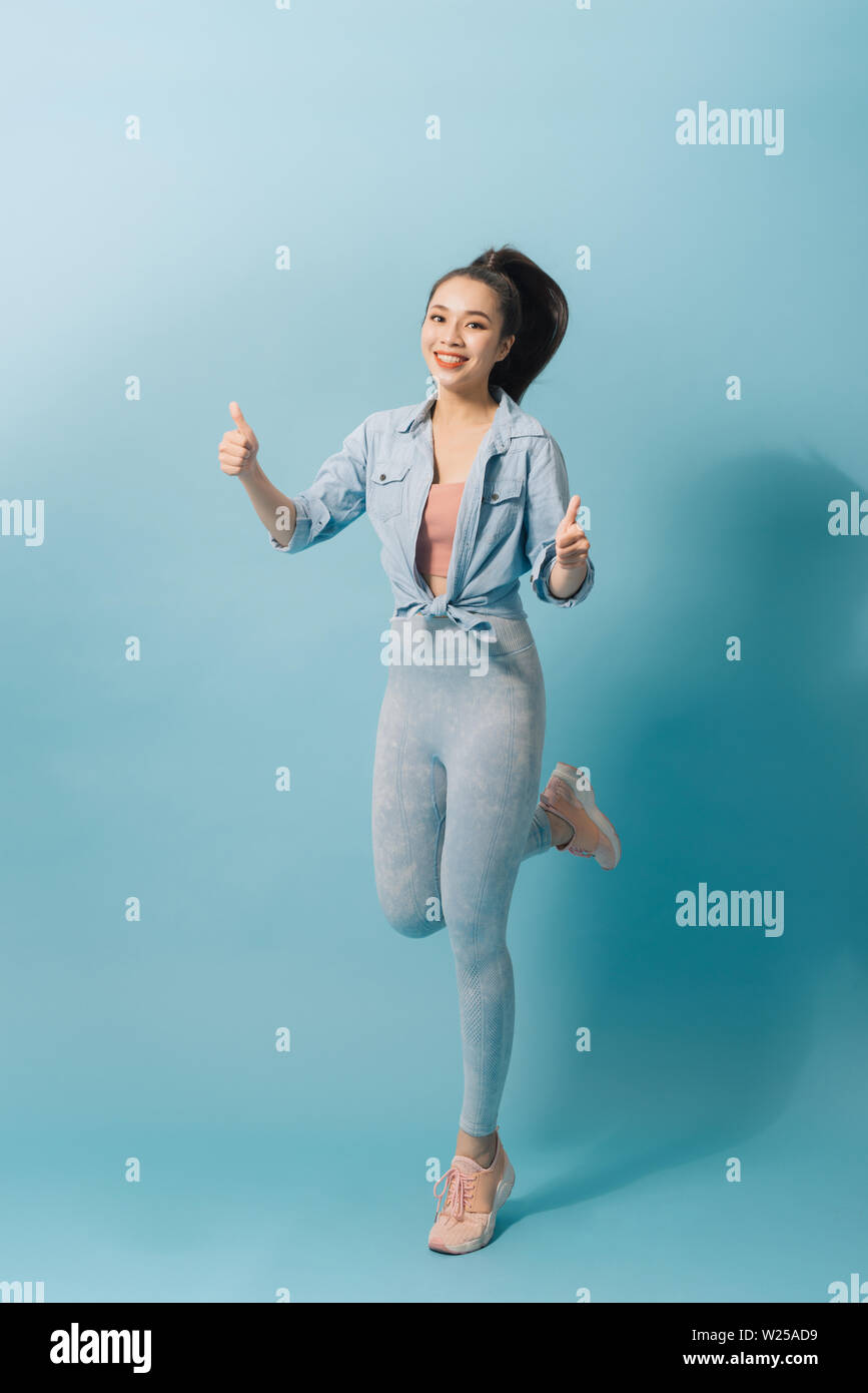 Charming excited crazy woman jumping up on light blue background Stock ...