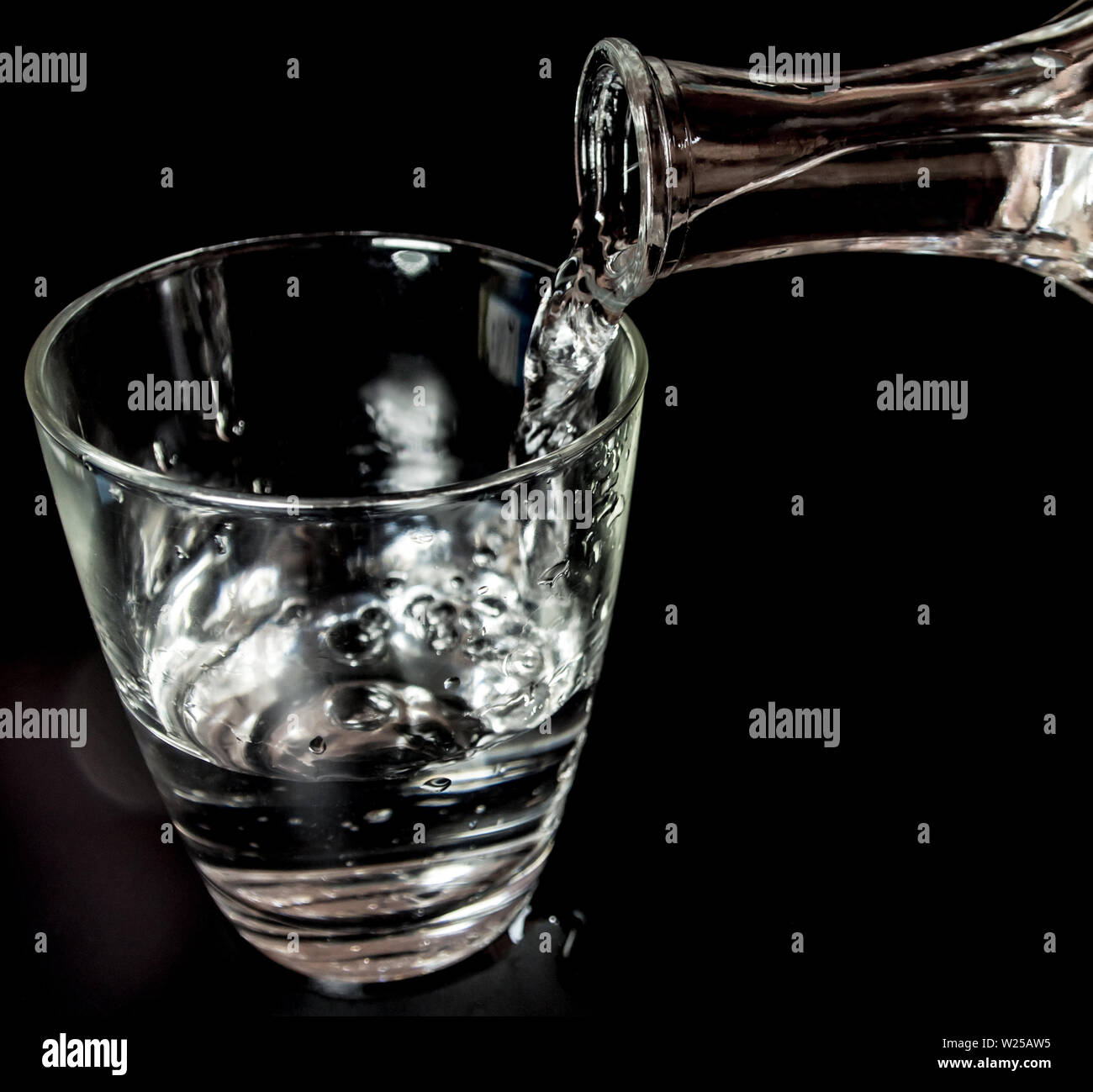 Pour water from the bottle into the glass Stock Photo - Alamy