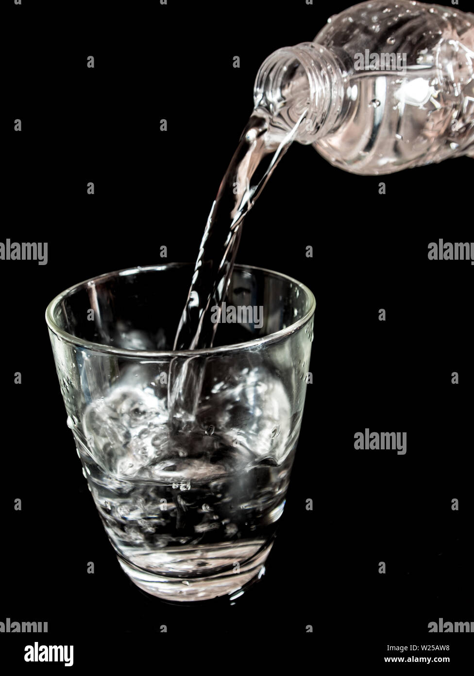 Pour water from the bottle into the glass Stock Photo - Alamy