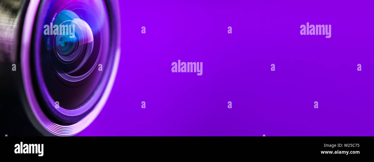 Banner. Camera lens and dark purple backlight. Side view of the lens of ...