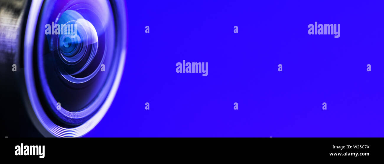 Banner. Camera lens and dark blue backlight. Side view of the lens of ...