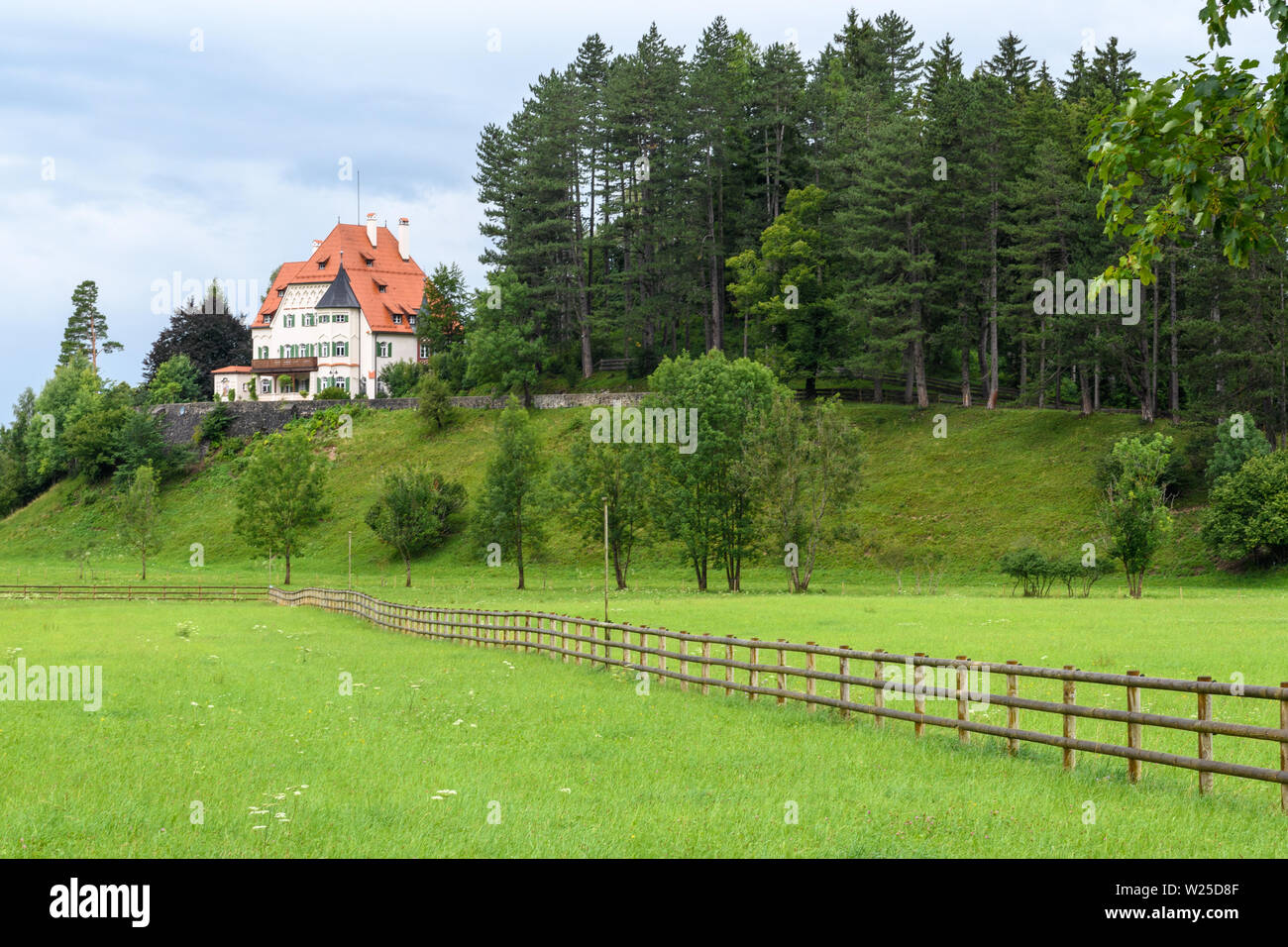 BAVARIA, GERMANY - JUL 2017: Cozy traditional Alpine house on a lush ...