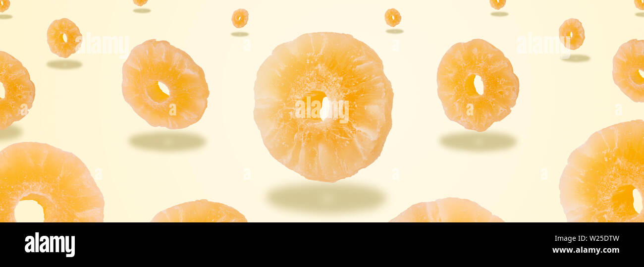 dried pineapple fruit levitating over yellow background, panoramic ...