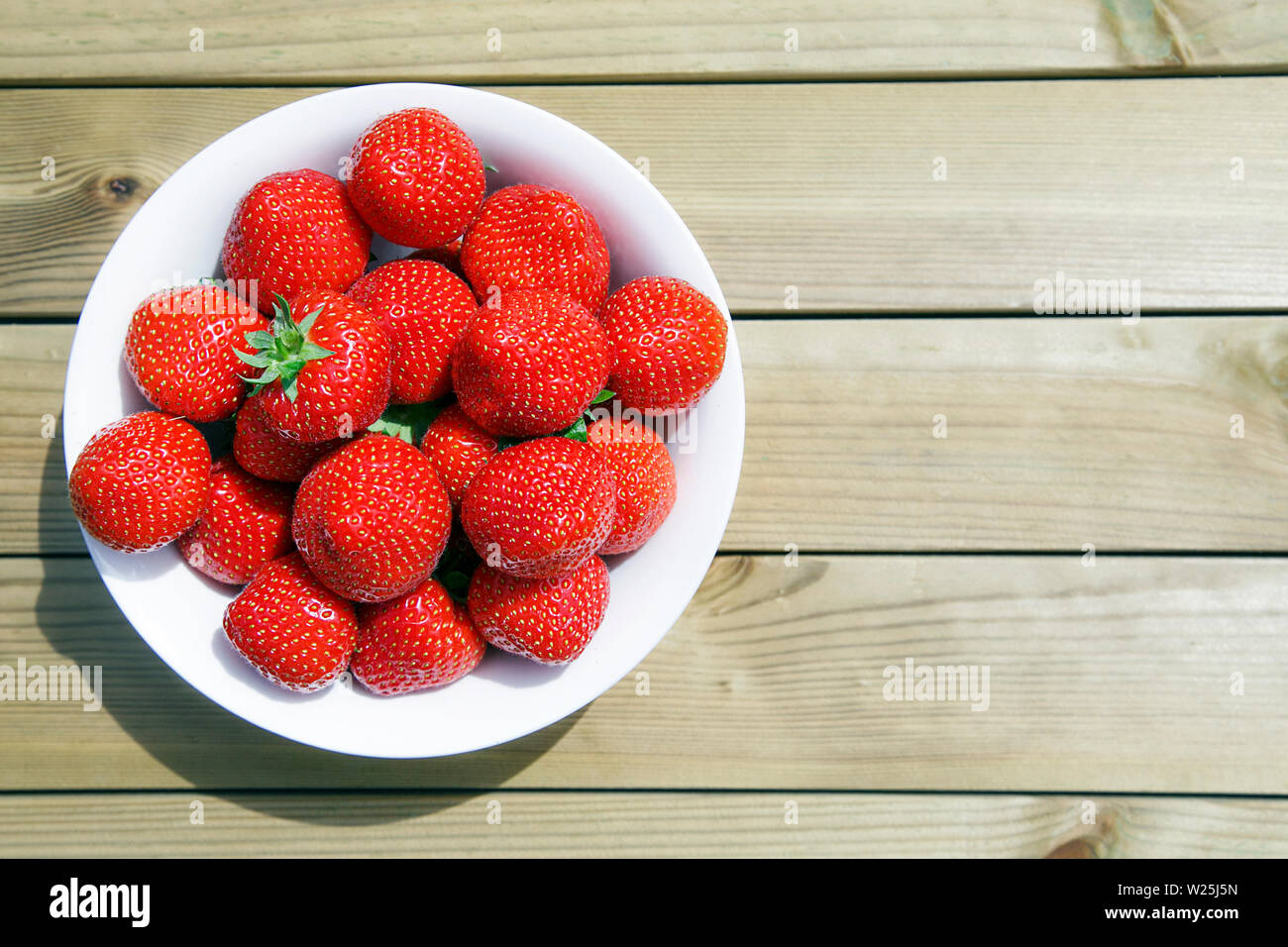 Strawberries on a wooden picnic table - summertime garden eating ...