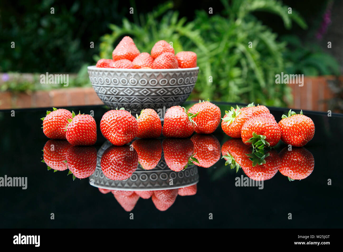 Strawberries on a glass picnic table with reflections - summertime ...