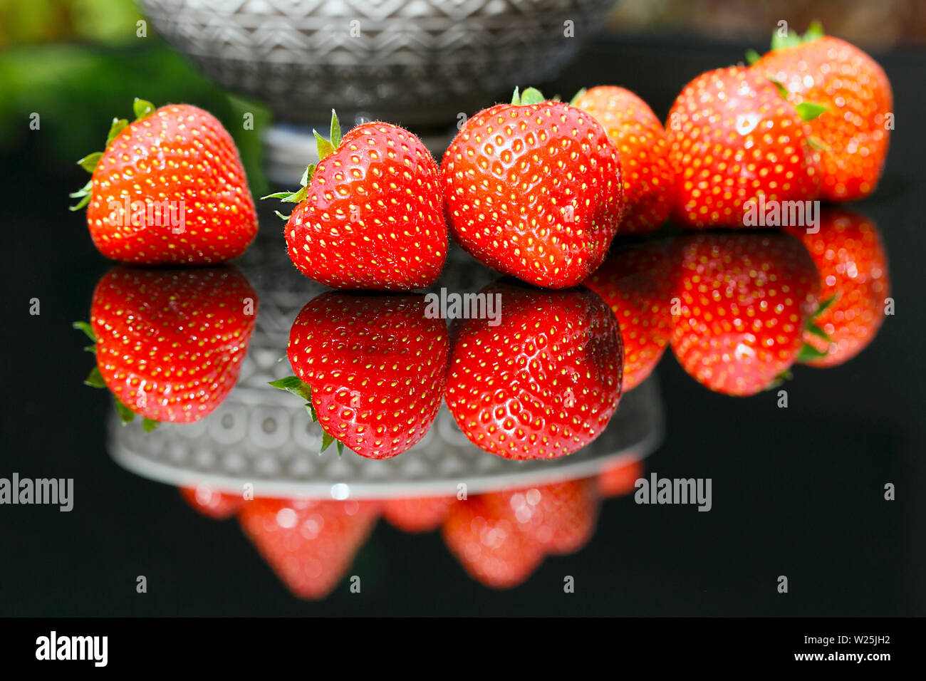Strawberries on a glass picnic table with reflections - summertime ...