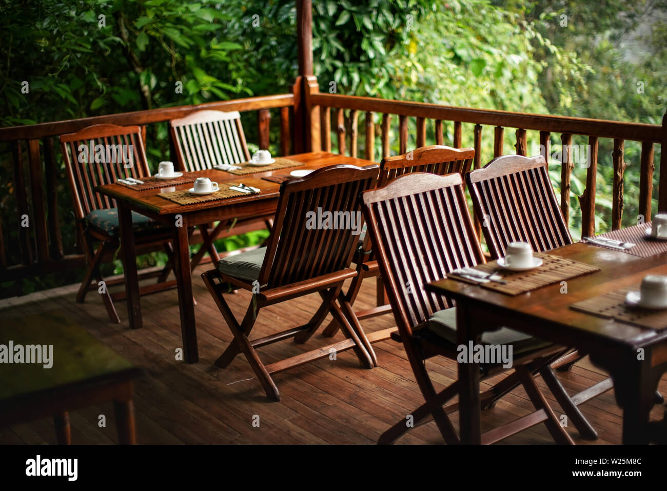 Empty wooden chairs and tables, with coffee cups upside down - ready ...