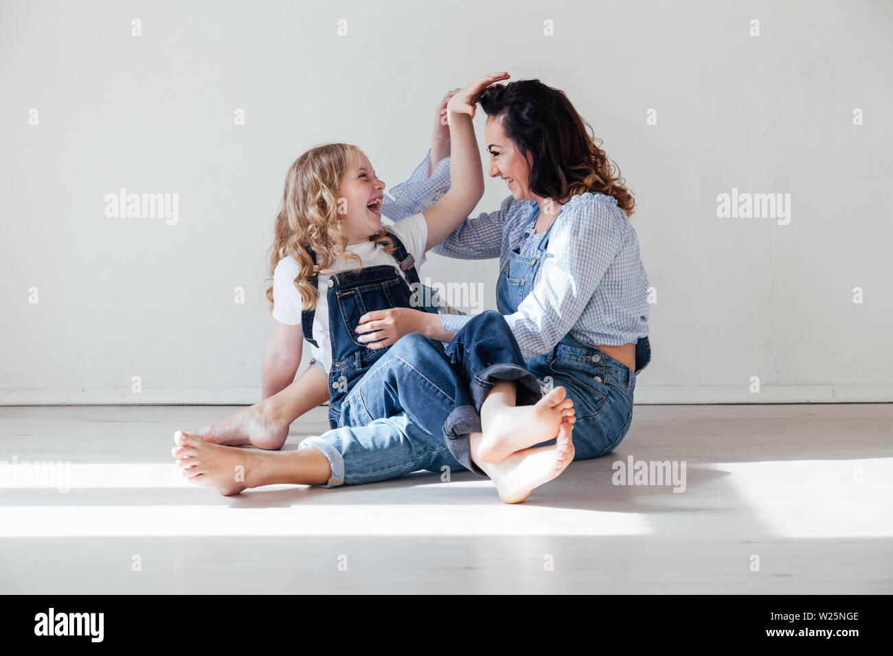 Mom and daughter play cuddles at home on the floor Stock Photo - Alamy
